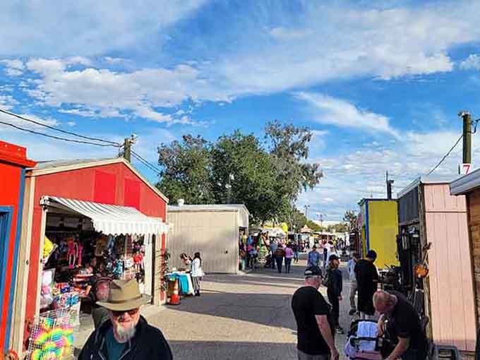 Bright red and yellow buildings pop against blue skies, creating a cheerful village atmosphere for weekend browsing.