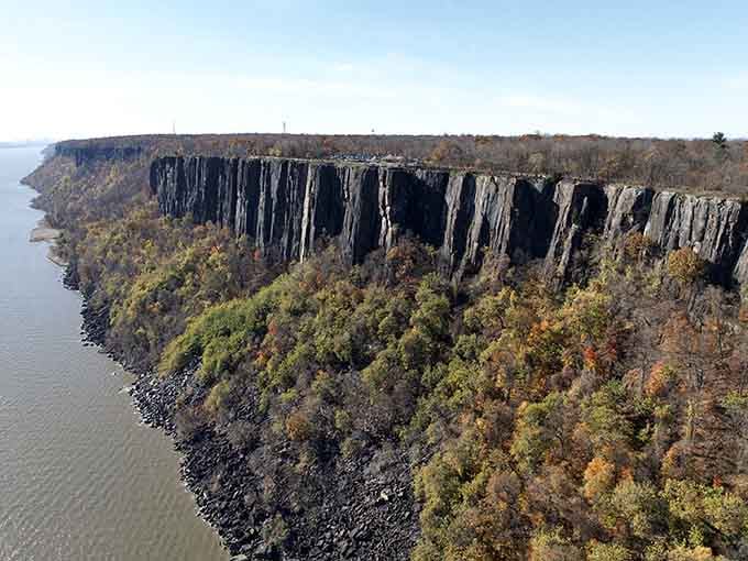 Towering volcanic columns rise like a fortress wall, their dark faces standing sentinel over the Hudson for millennia.