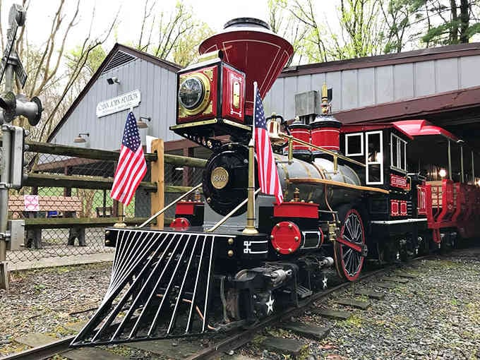 American flags frame this stunning locomotive like it's posing for its own postage stamp, and honestly, it should be.
