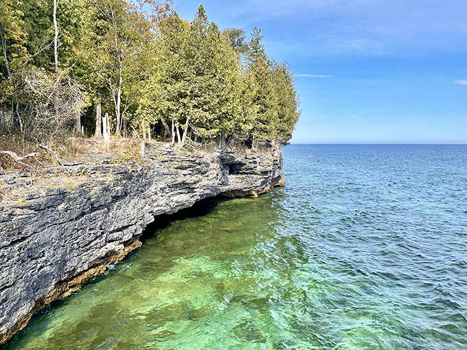 Lake Michigan's turquoise waters lap against ancient rock formations, creating a scene worthy of any tropical postcard.