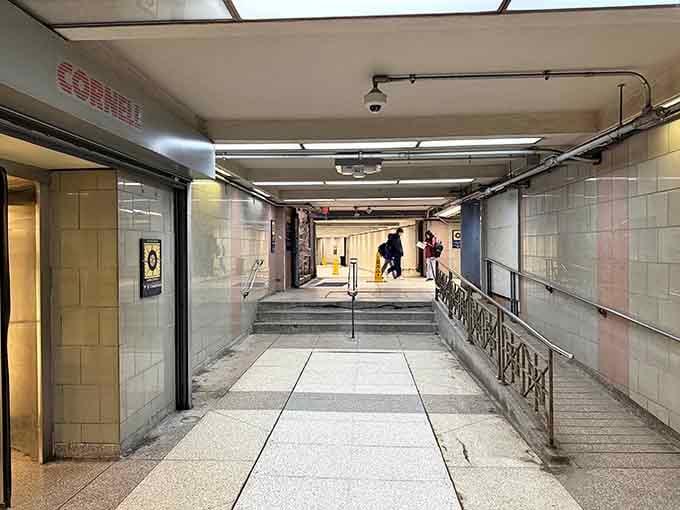Vintage tile walls and industrial pipes create an unexpectedly artistic backdrop in this utilitarian passage connecting the city above.