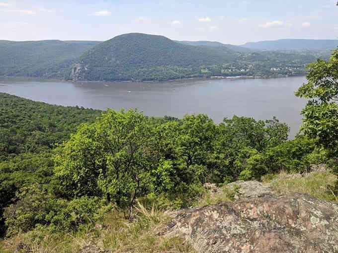 From this rocky perch, the Hudson River spreads below like a silver ribbon connecting past and present.