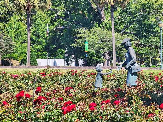 A bronze statue stands among the roses, adding a touch of history to this fragrant and beautiful garden.