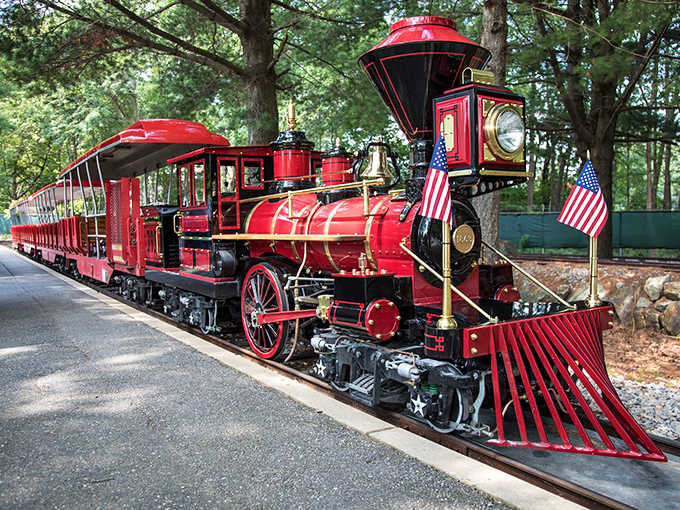 That polished crimson engine could've rolled straight out of a Norman Rockwell painting, flags flying and whistle ready.