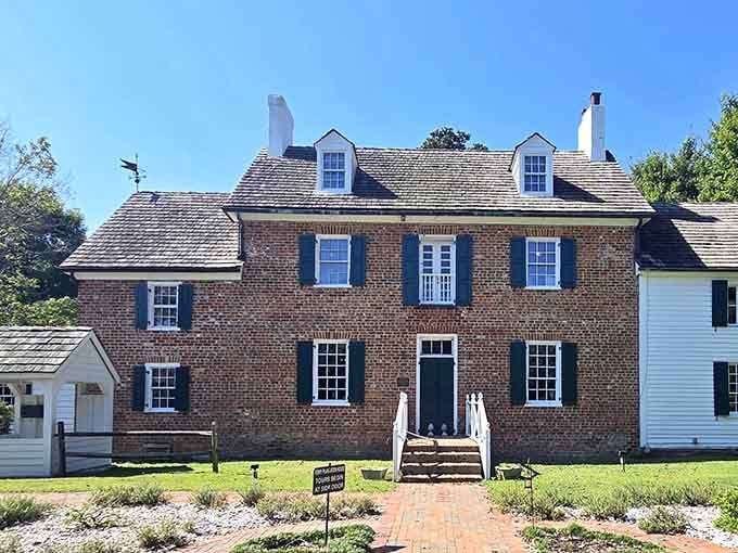Blue shutters pop against warm brick under perfect skies&mdash;colonial charm meets picture-perfect summer afternoon.