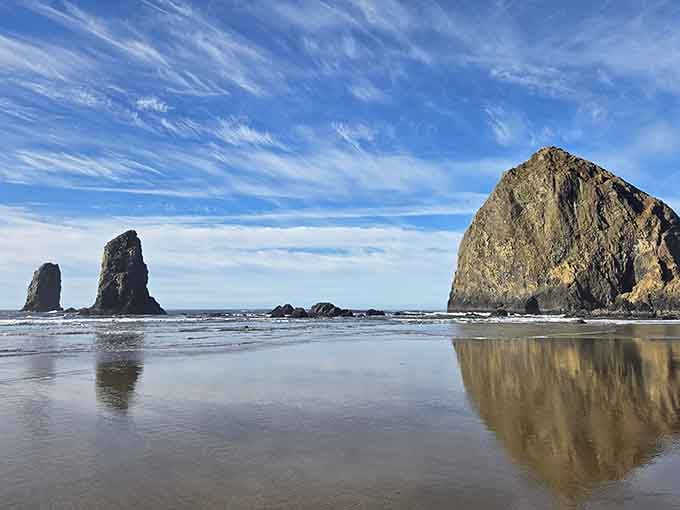 Low tide reveals the rock's perfect mirror image, doubling the magic of this iconic coastal giant standing guard.