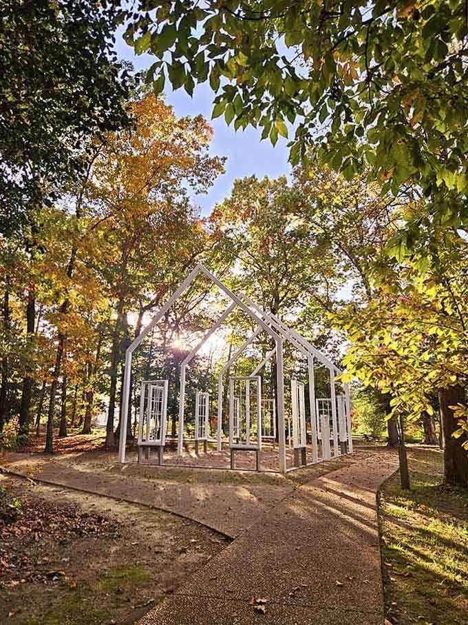 Autumn leaves frame this architectural meditation on memory, where empty windows invite contemplation beneath golden branches and dappled sunlight.