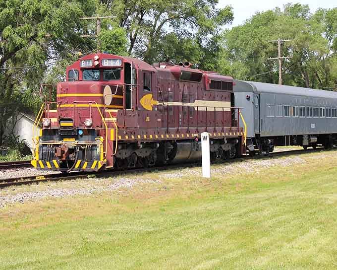 That burgundy diesel pulls passenger cars through peaceful countryside, offering views your car windshield could never match.