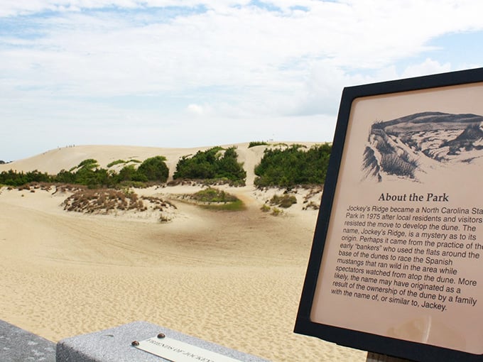 The informational plaque tells the story while golden dunes stretch endlessly behind it, like Lawrence of Arabia meets the Outer Banks.