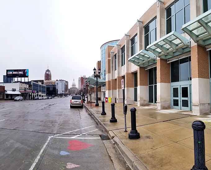 Modern glass canopies shelter sidewalks where government workers and locals share coffee breaks, blending old-world elegance with contemporary convenience.