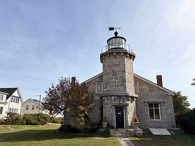 Autumn leaves frame this sturdy stone lighthouse like nature's own picture frame for maritime history buffs everywhere.