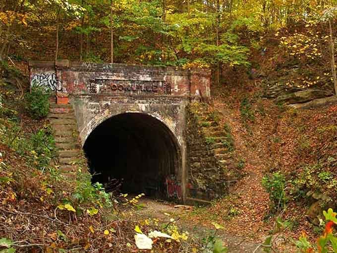 Nature reclaims this abandoned tunnel entrance, creating an eerie beauty that photographers absolutely love capturing.