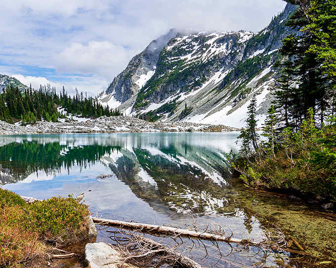 That alpine lake mirrors the mountains so perfectly you'll wonder which side is up in this postcard.