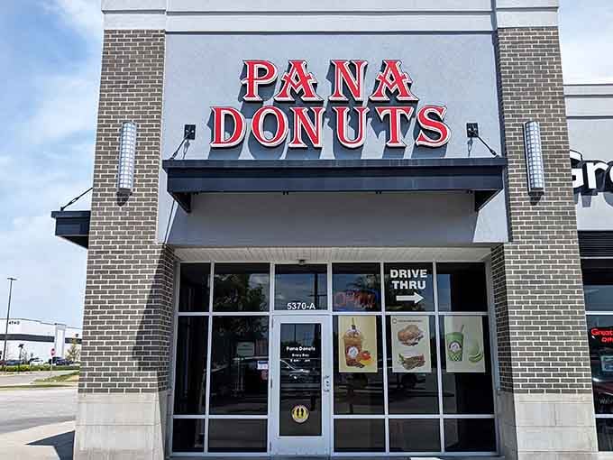 Modern brick facade meets timeless donut tradition, where fresh glazed treats await just beyond those welcoming glass entrance doors.