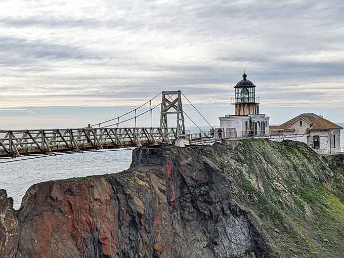 The dramatic cliffside setting and colorful rock layers create a natural masterpiece framing this historic coastal guardian beautifully.