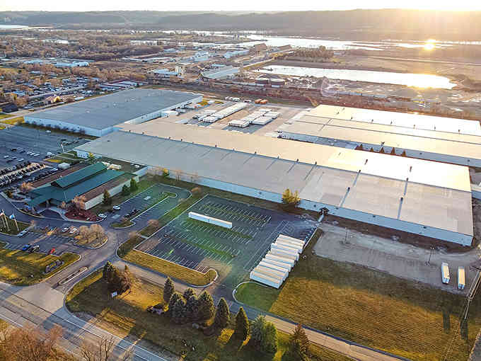 Golden hour bathes industrial buildings in warm light, showing how working towns can shine just as bright.