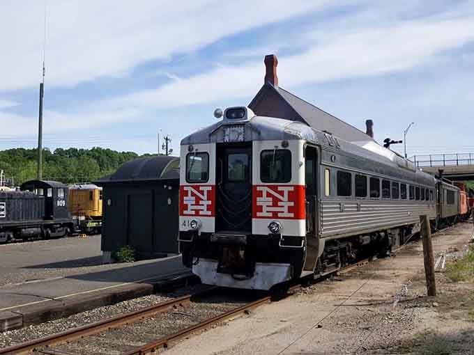 The sleek silver passenger car with its distinctive red accents represents mid-century rail design at its finest.