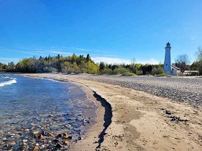 The rocky beach stretches endlessly beside this tower, inviting barefoot walks and quiet contemplation of Lake Huron's moods.
