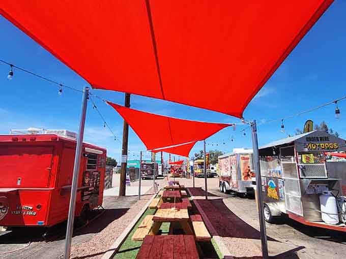 Bold red shade sails overhead make this outdoor dining area feel like a modern desert oasis.