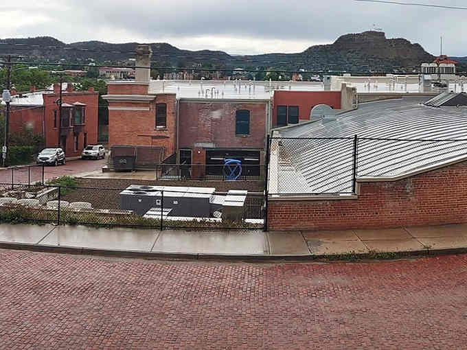 Rain-slicked rooftops and dramatic skies create that moody atmosphere Ansel Adams would've loved to photograph all day.