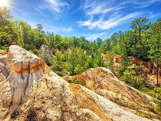 Sunlight dances across these layered geological formations, revealing millions of years written in stone and sediment.