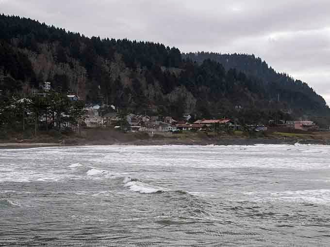 Moody waves roll toward shore beneath dramatic cliffs in this rugged corner where land meets restless sea.
