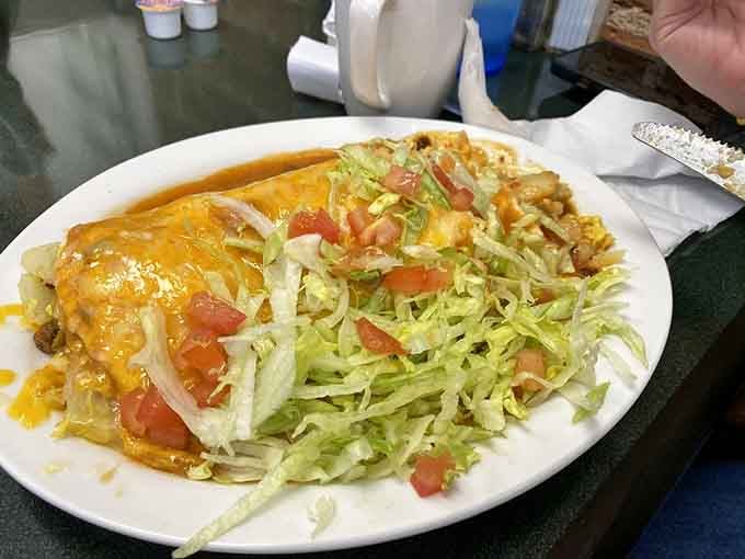 Behold the smothered breakfast burrito, drowning in green chile glory like a delicious edible swimming pool.