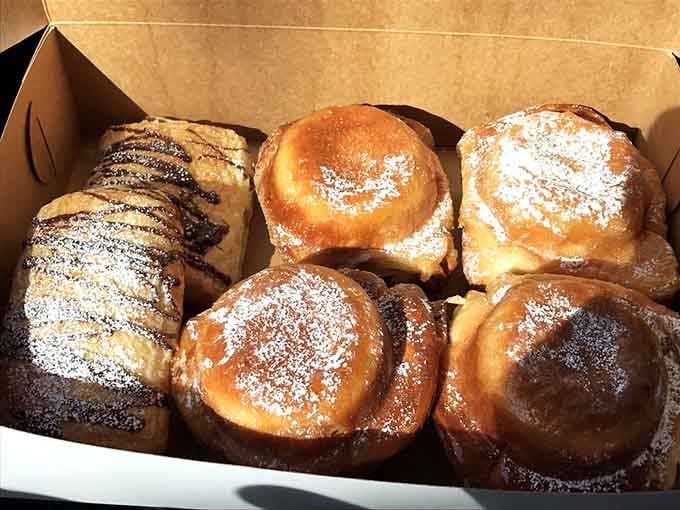 A box of American Tea Cakes dusted with powdered sugar, ready to make any gathering instantly better.