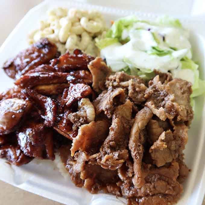 BBQ chicken and teriyaki beef share the spotlight with mac salad, proving Hawaii perfected the plate lunch formula long ago.
