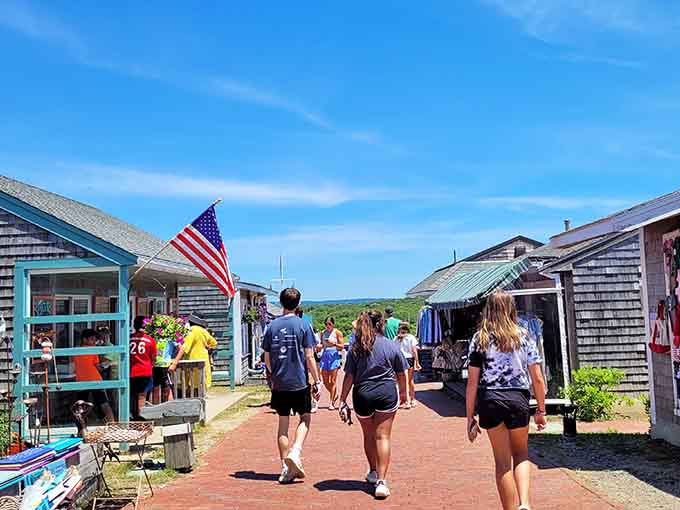 Summer crowds stroll past weathered shingles and American flags, hunting for the perfect souvenir and lobster roll.