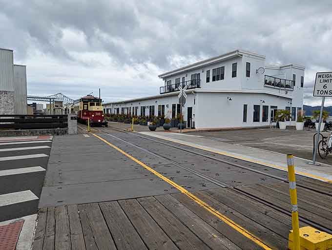 Modern cars politely wait as history rolls past&mdash;a delightful reversal of the usual order.