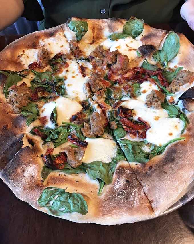 Fresh basil on a perfectly charred crust is the kind of simple beauty that makes life worth living.