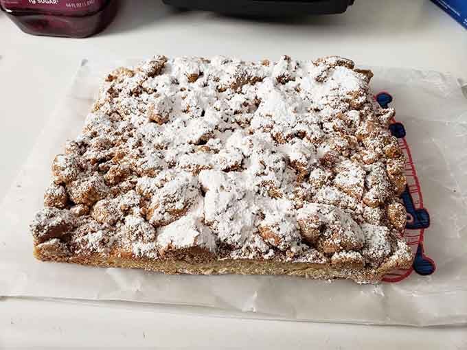 Behold the legendary crumb cake, dusted with enough powdered sugar to make a snow globe jealous and utterly magnificent.