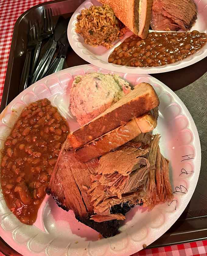 This plate showcases the holy trinity: tender brisket, perfectly smoked ribs, and sides that deserve their own fan club.