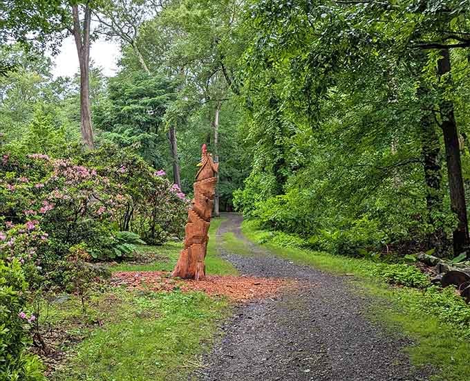 That carved wooden sculpture stands guard like nature's own welcoming committee along the peaceful path.