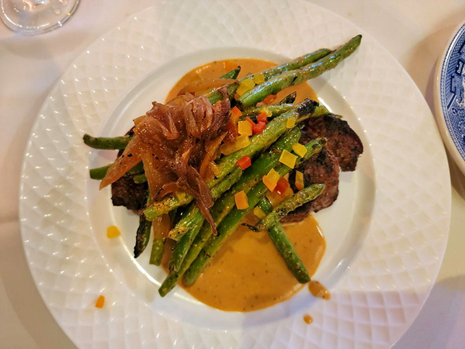 Perfectly cooked sirloin topped with crispy onions and vibrant asparagus, because even royalty appreciates good plating.