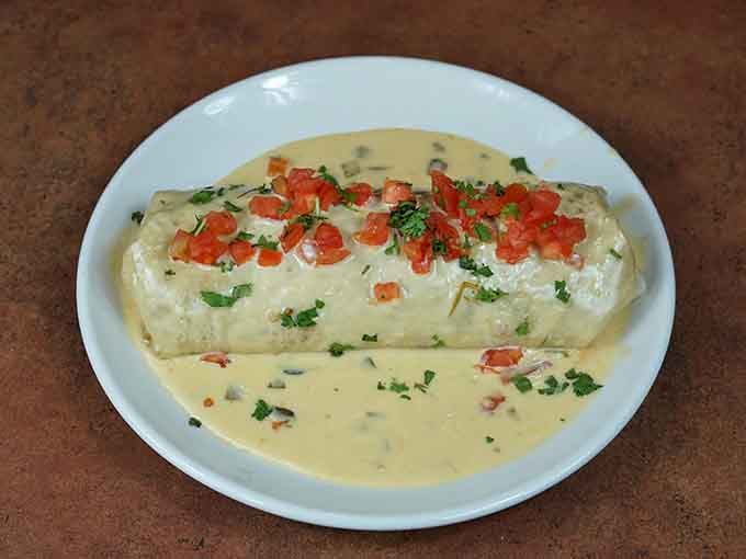 Behold the famous wet burrito, swimming in creamy sauce and looking absolutely magnificent in its saucy glory.