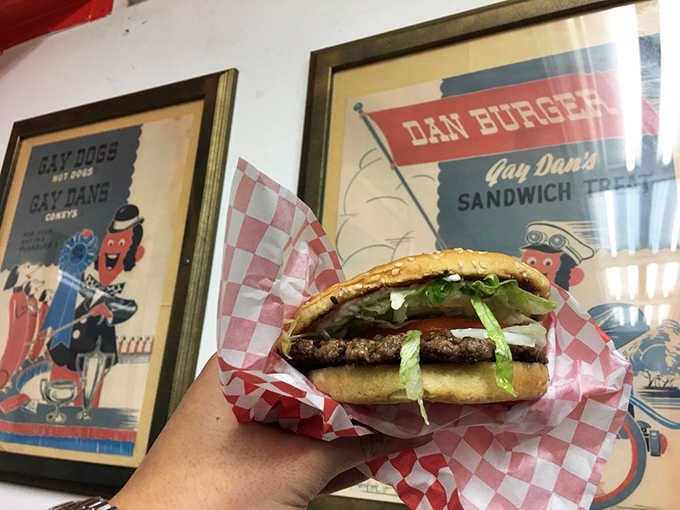 This burger sits pretty against vintage diner memorabilia, proving some things never go out of style.