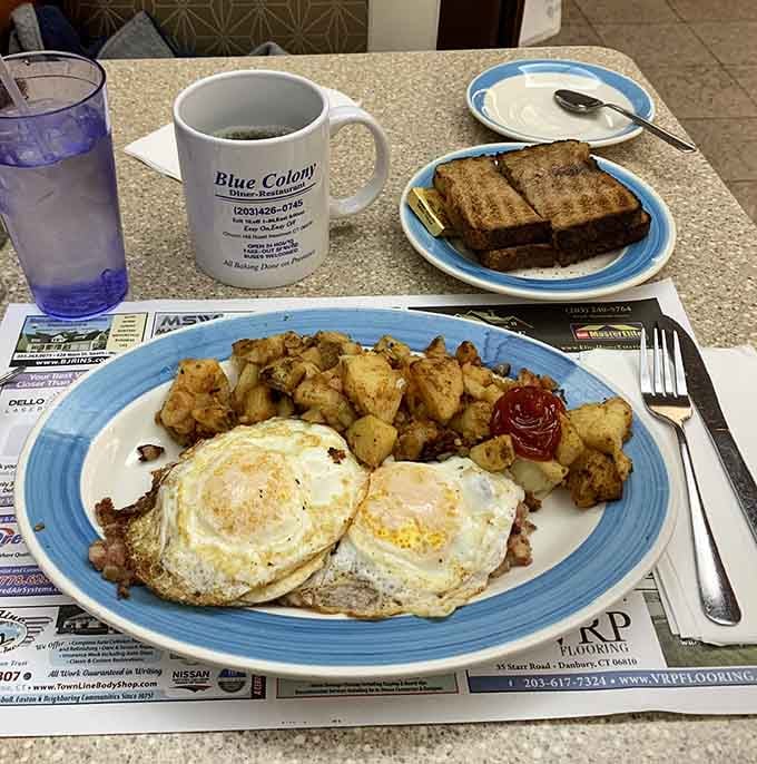 Two perfectly fried eggs with golden home fries and toast: simple perfection that never goes out of style.