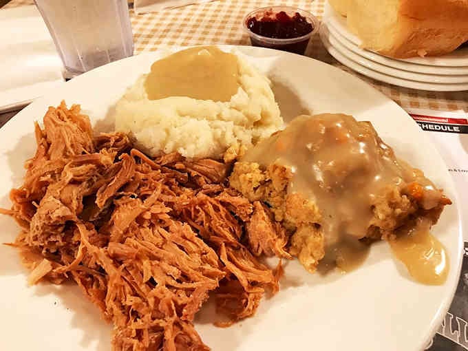 Tender pulled pork, creamy mashed potatoes, and gravy that could solve world problems, all on one glorious plate.