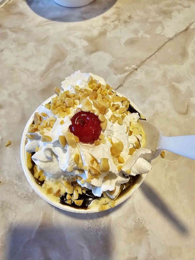 This hot fudge sundae towers like a delicious skyscraper, proving that structural engineering has its place in dessert.