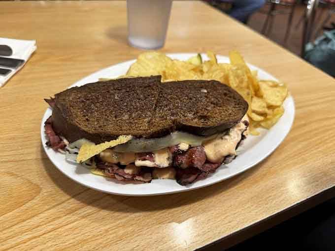 The Russian Reuben arrives like a masterpiece, stacked high with corned beef and topped with crispy chips for maximum crunch satisfaction.