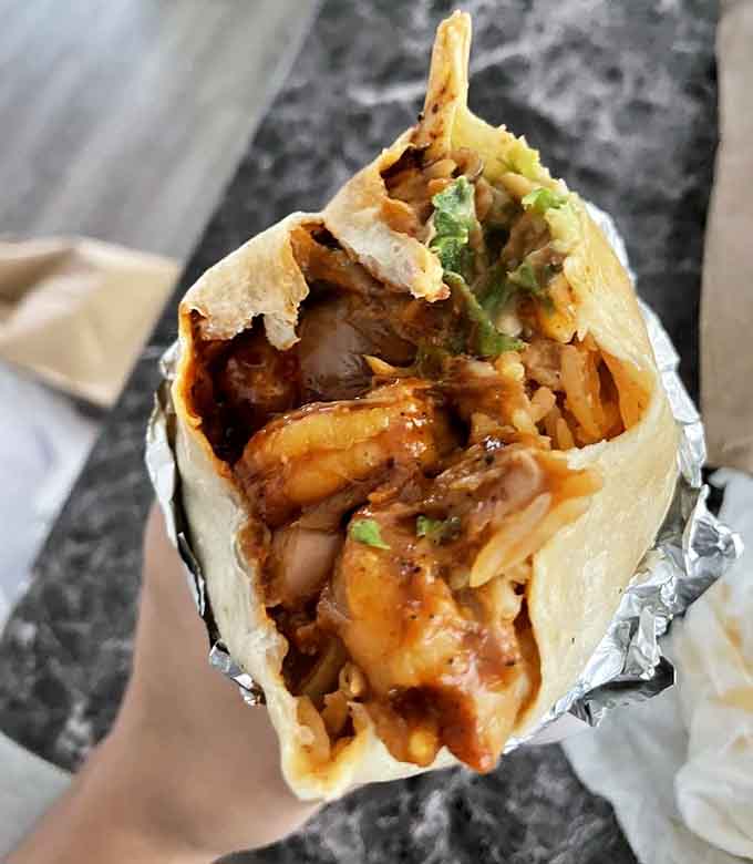 This grilled shrimp burrito is wrapped tighter than a drum and packed with flavor that defies its location.