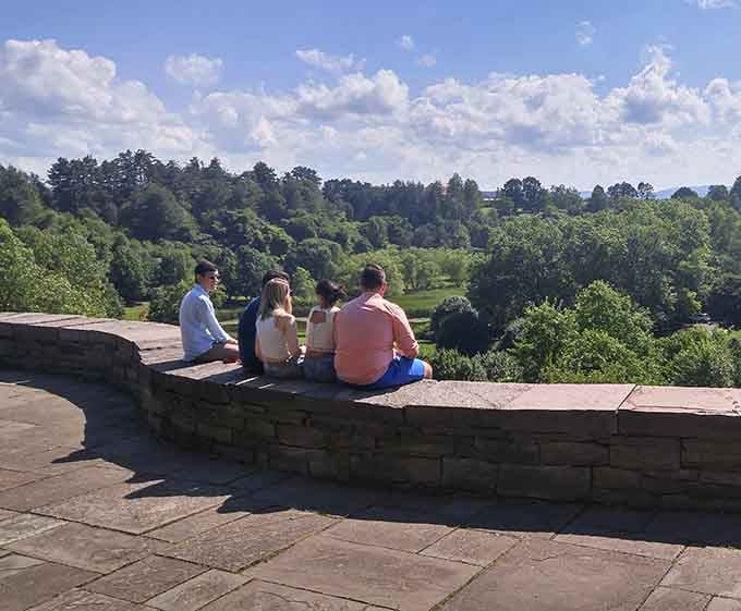 Five friends sharing a quiet moment, proving the best conversations happen with sweeping valley views as backdrop.