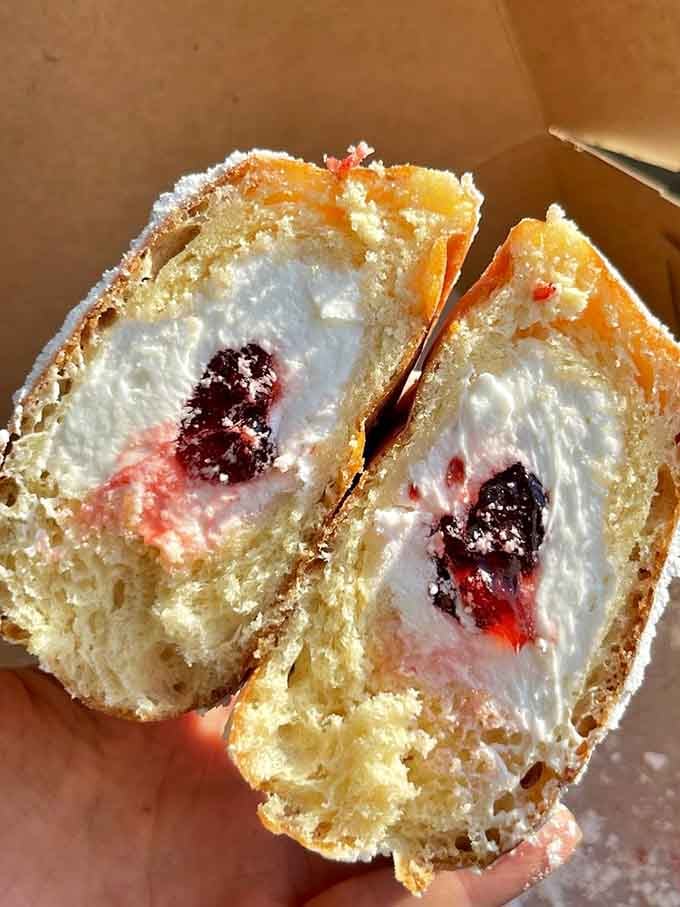 Strawberry paczki cut open to reveal layers of cream and fruit that make regular donuts look positively underdressed.