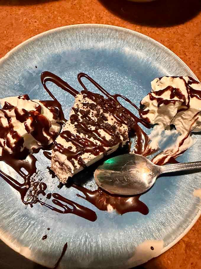 Chocolate drizzle cascading over creamy cheesecake proves that dessert is always worth saving room for, somehow.