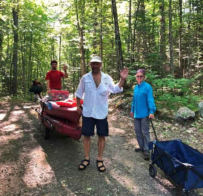 Nothing says adventure like hauling your kayak through the woods with friends who clearly lost the coin toss.