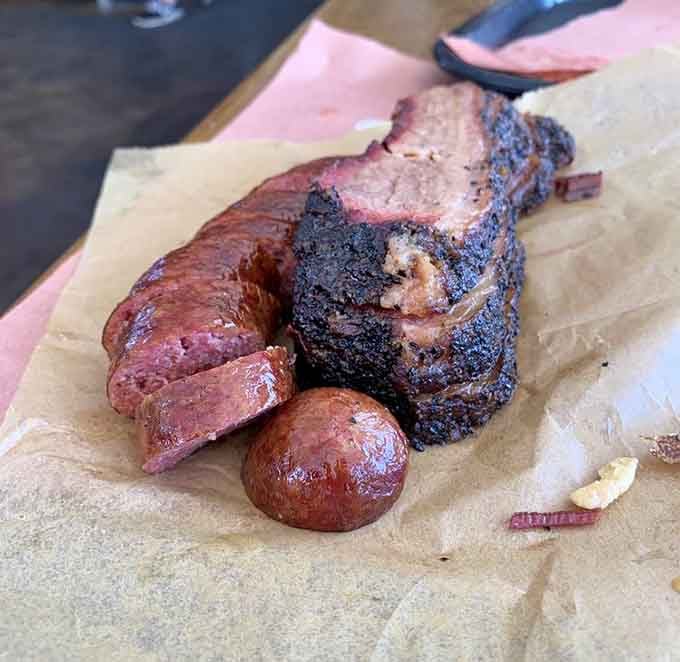 Behold the holy trinity: brisket with that perfect bark, sausage with snap, and pure smoky satisfaction on butcher paper.