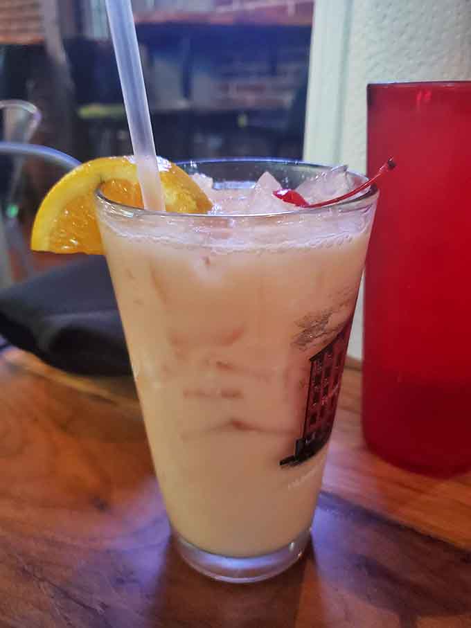 Creamy, fruity, and garnished with orange and cherry, this pi&ntilde;a colada looks like vacation in a glass.