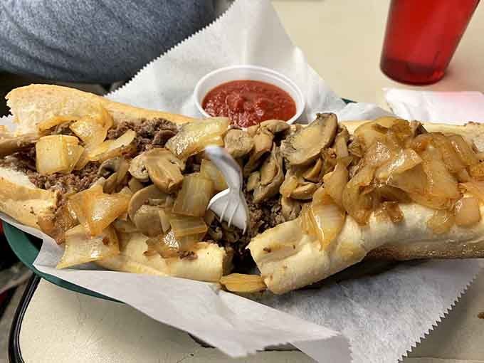 Behold the masterpiece: a cheesesteak with thinly sliced ribeye, caramelized onions, and melted cheese on a fresh roll that holds together.